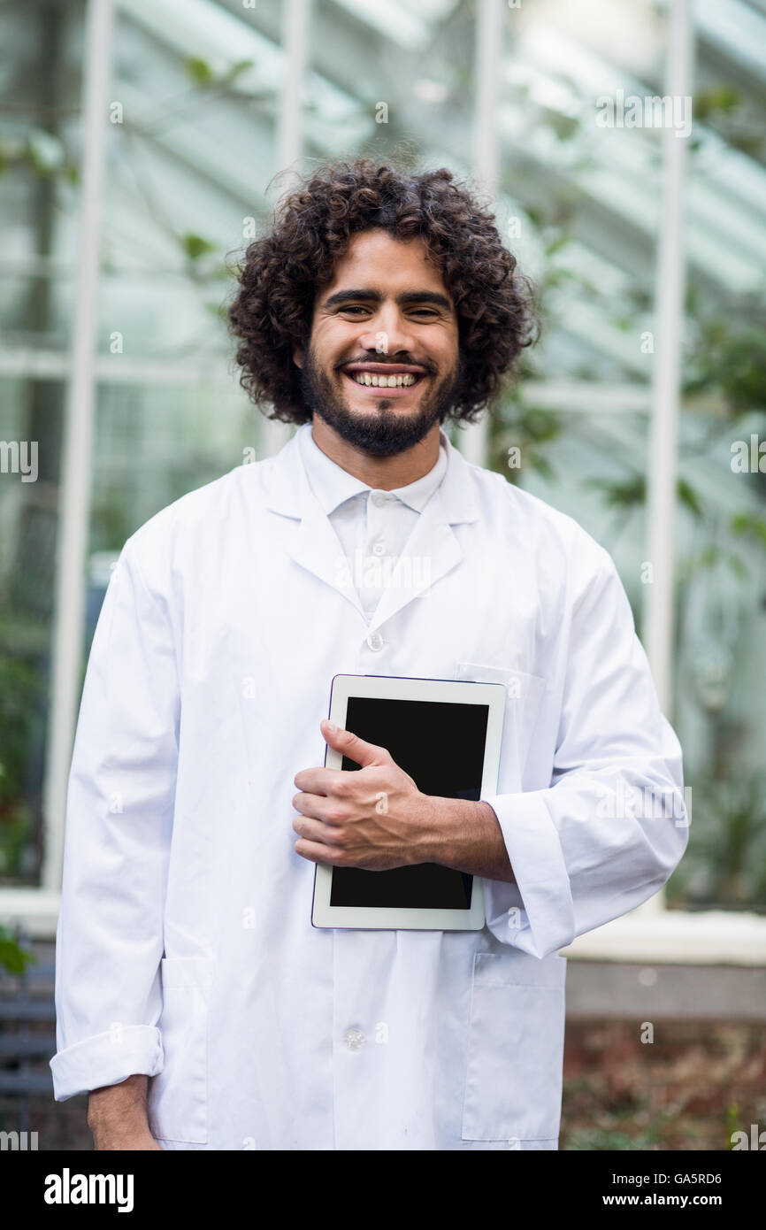 Male scientist holding digital tablet outside greenhouse Stock Photo ...