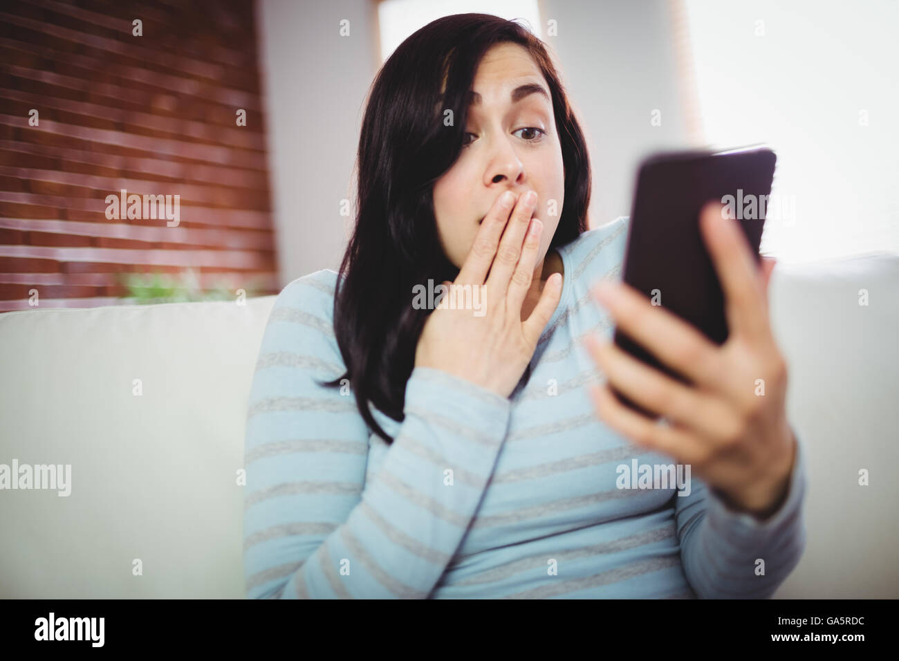 Shocked woman using mobile phone Stock Photo - Alamy
