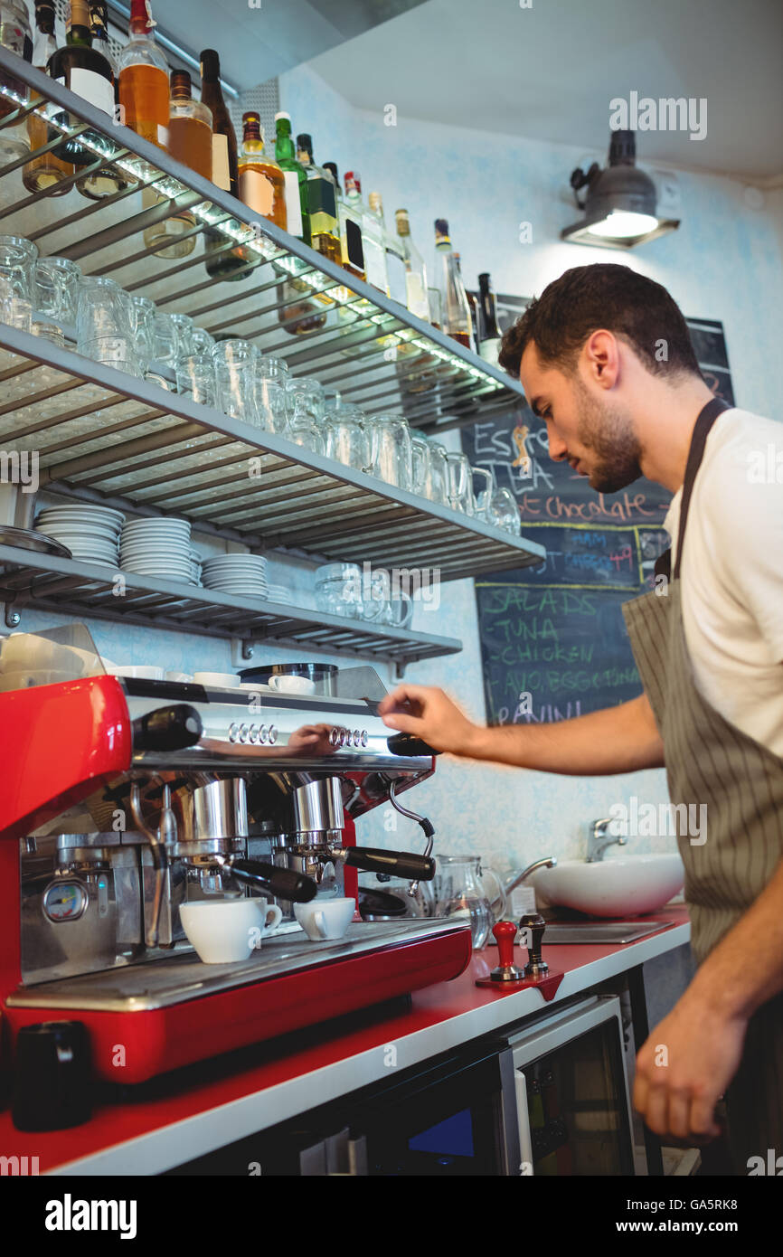 Side view of waiter using coffee maker at cafe Stock Photo - Alamy