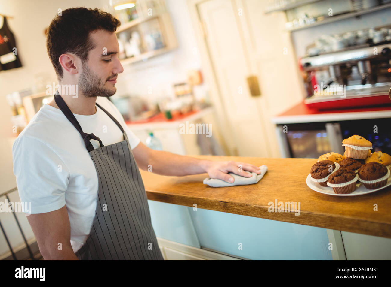 Handsome waiter cleaning counter Stock Photo - Alamy