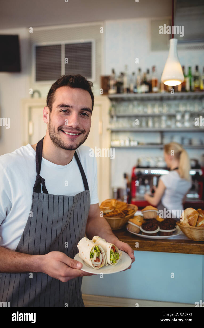 Portrait of happy waiter with fresh rolls at cafe Stock Photo - Alamy