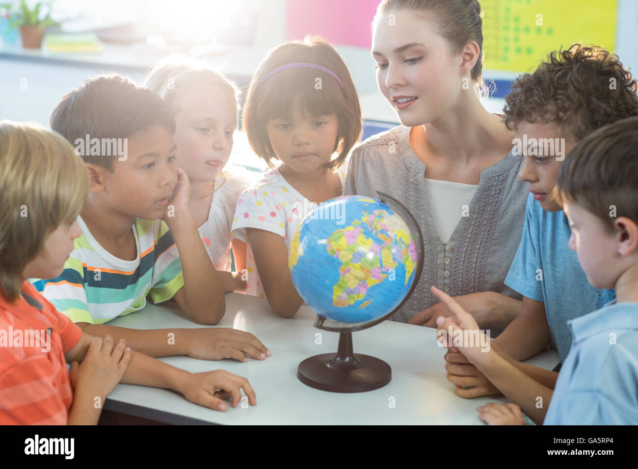 Teacher showing globe to schoolchildren Stock Photo - Alamy