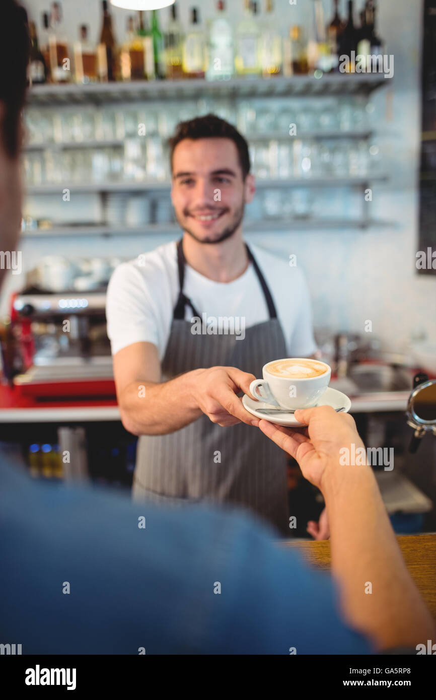 Customer taking coffee from happy waiter at cafe Stock Photo - Alamy