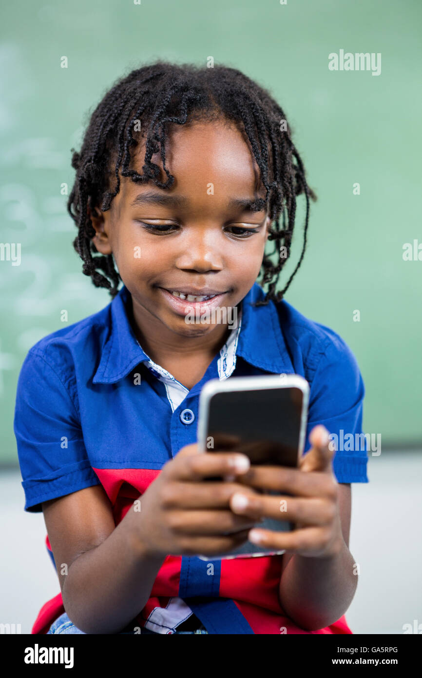 Smiling boy using mobile phone in classroom Stock Photo - Alamy