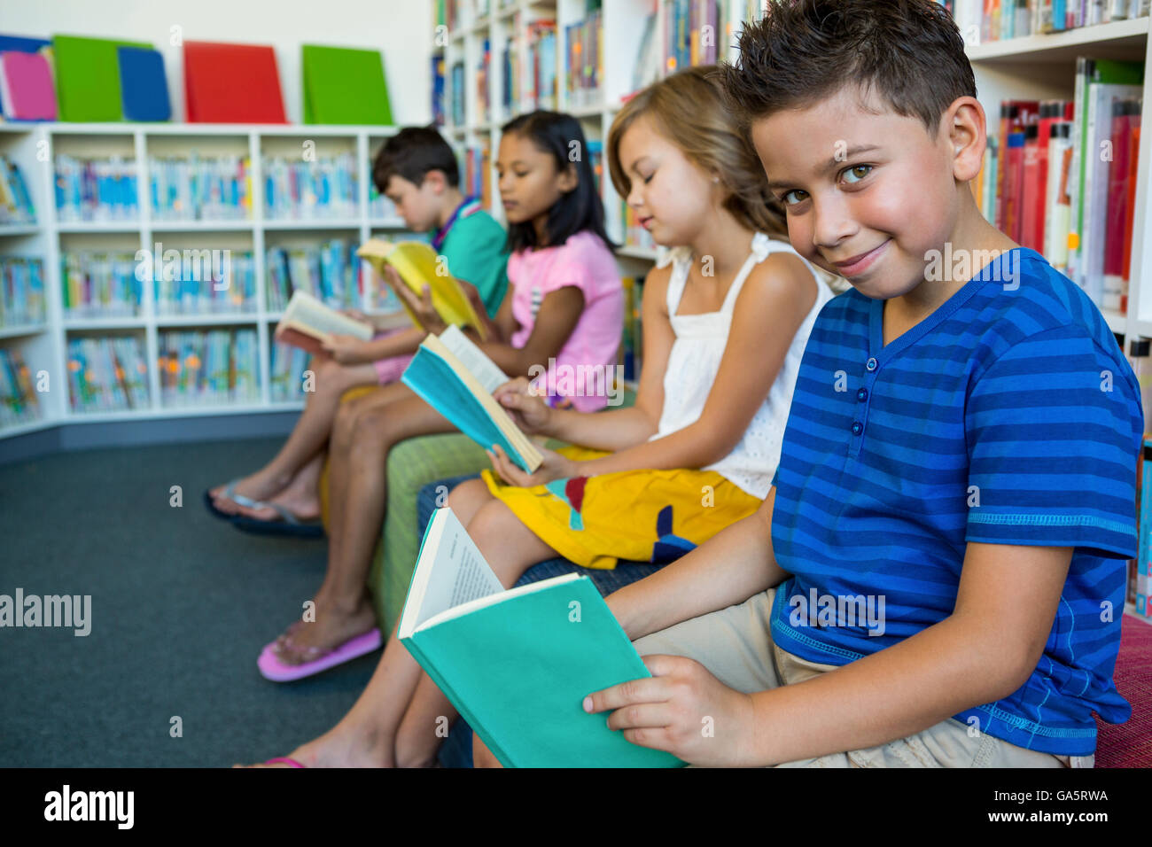 Elementary students reading books in library Stock Photo - Alamy