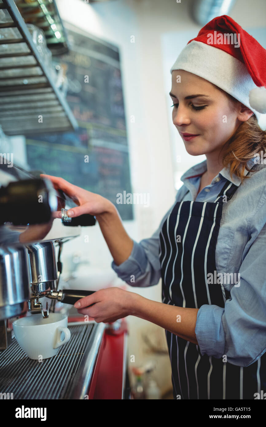 Waitress wearing Santa hat using espresso maker at cafe Stock Photo - Alamy