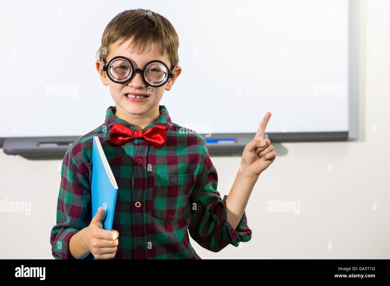 Boy raising hand in classroom hi-res stock photography and images - Alamy