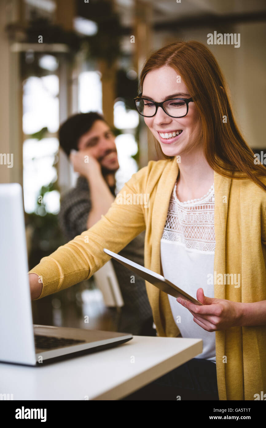 Businesswoman using laptop with male coworker Stock Photo - Alamy