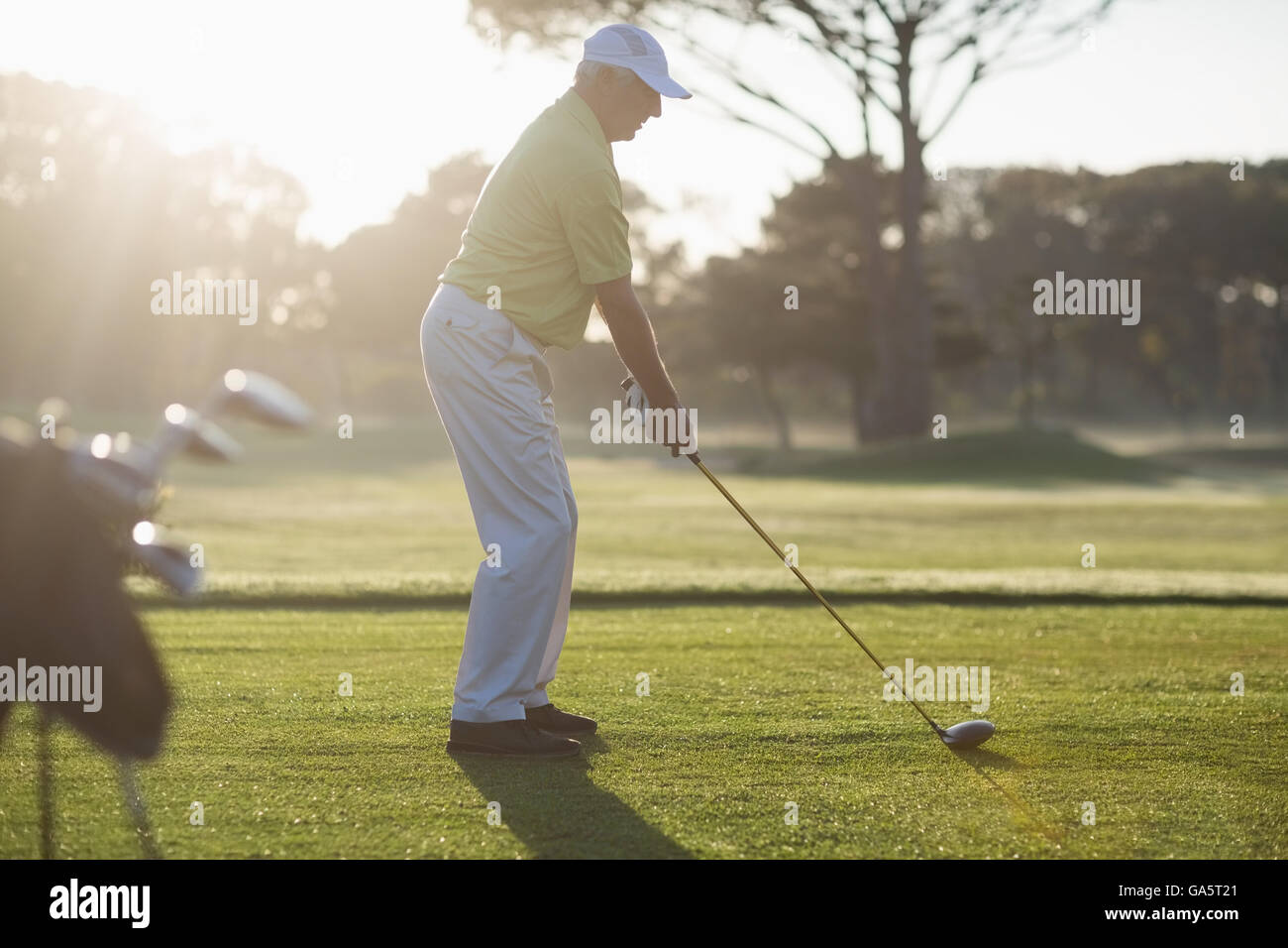 Full length side view of mature man playing golf Stock Photo - Alamy