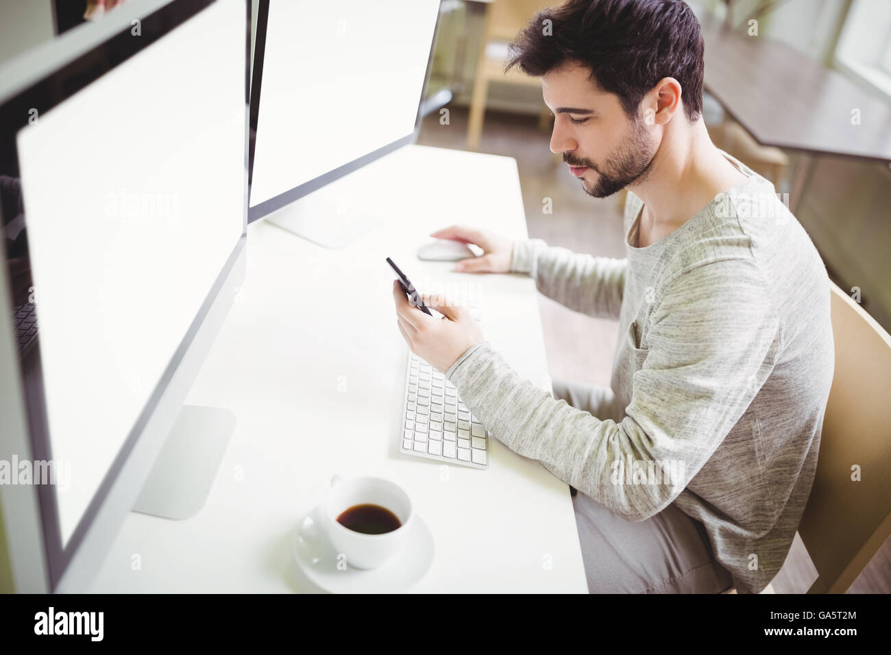 Businessman using mobile phone at desk Stock Photo - Alamy