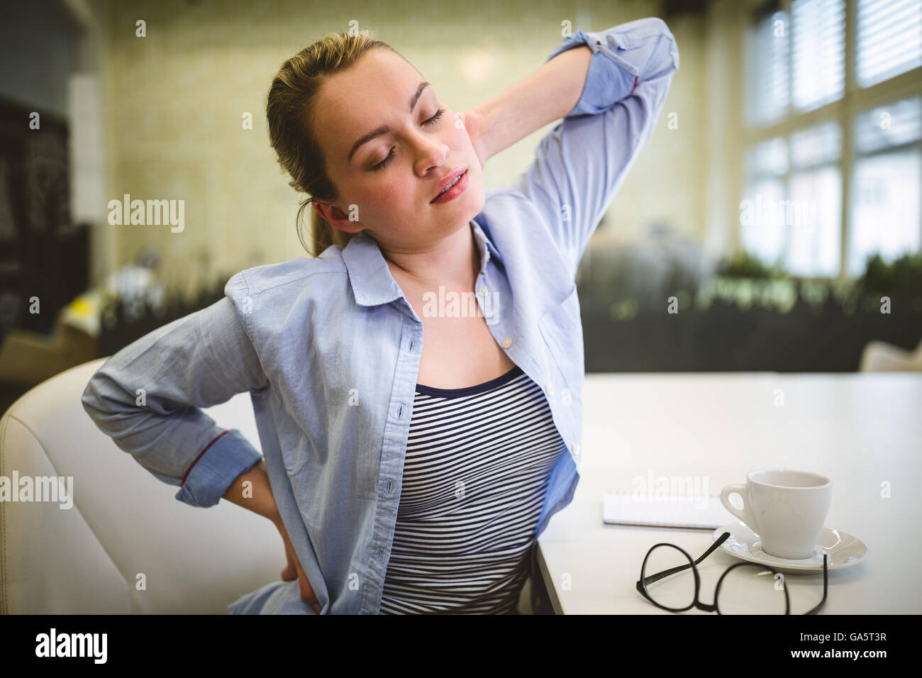 Tired businesswoman stretching Stock Photo - Alamy