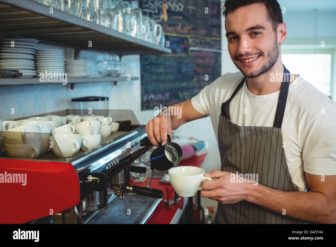 Portrait of happy barista pouring coffee at cafe Stock Photo - Alamy