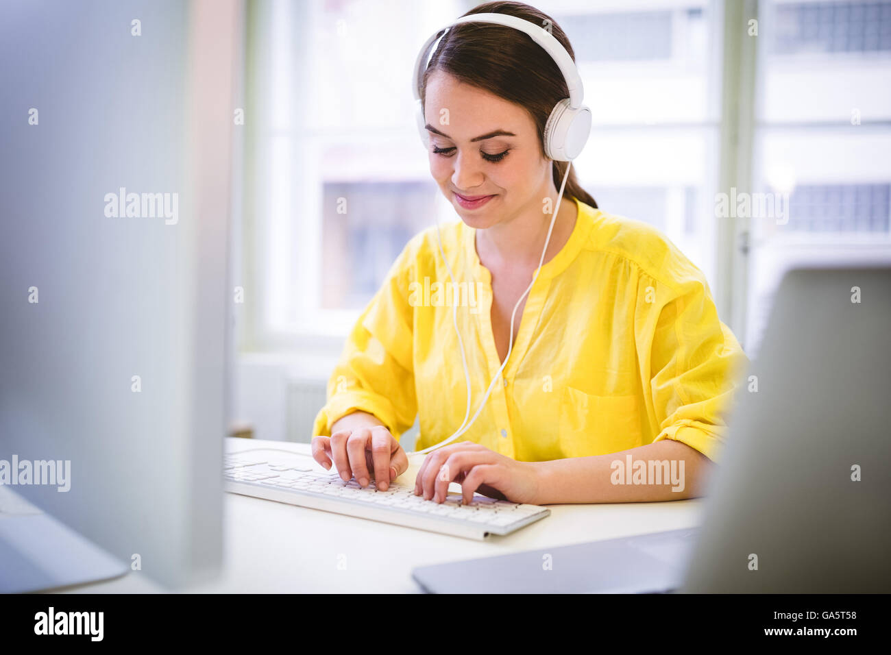 Happy executive typing on keyboard at creative office Stock Photo - Alamy
