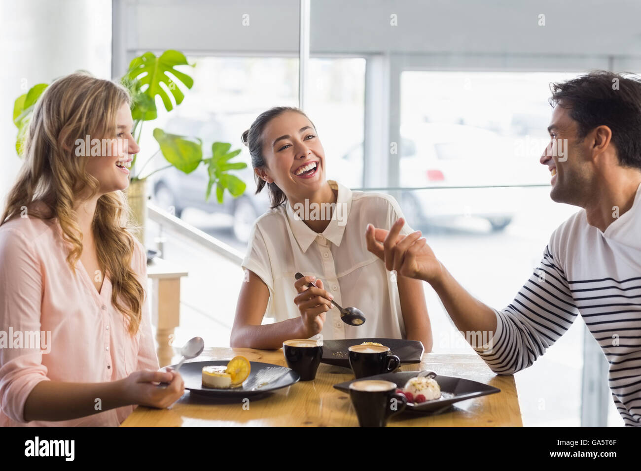 Group of happy friends having dessert together Stock Photo - Alamy
