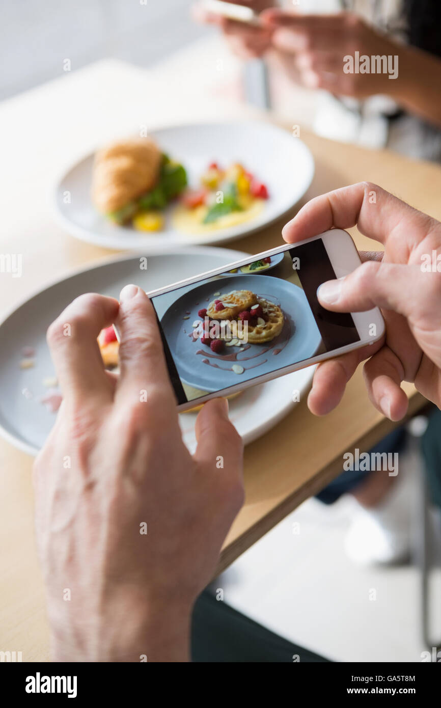 Couple taking a photo of their snacks Stock Photo - Alamy