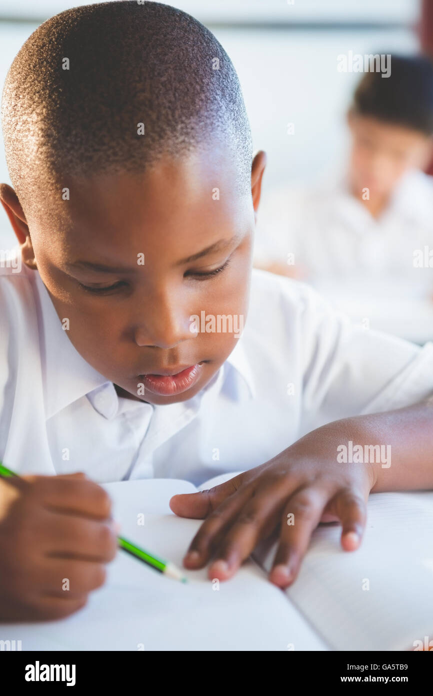 Schoolboy doing homework in classroom Stock Photo - Alamy