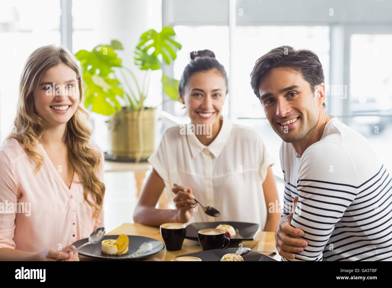 Group of happy friends having dessert together Stock Photo - Alamy