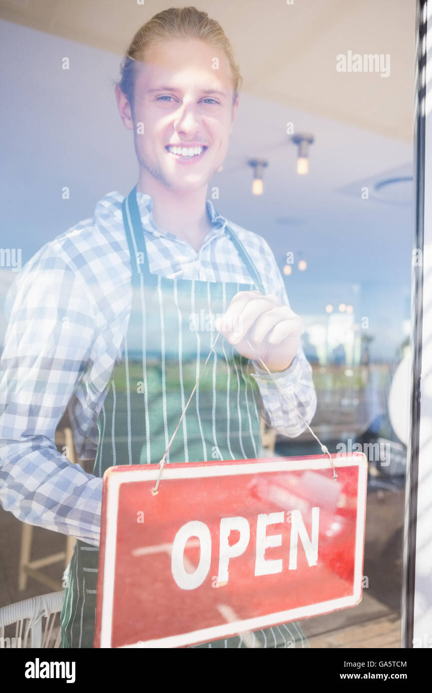 Waiter holding open signboard Stock Photo - Alamy