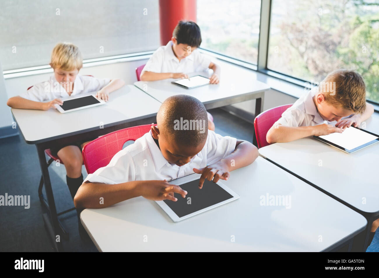 Schoolkids using digital tablets in classroom Stock Photo - Alamy