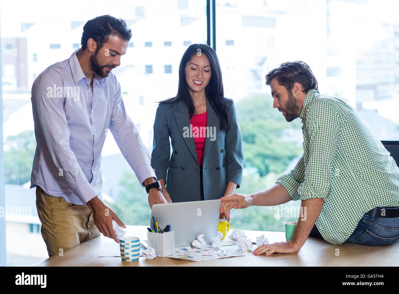 Colleagues discussing at desk Stock Photo - Alamy