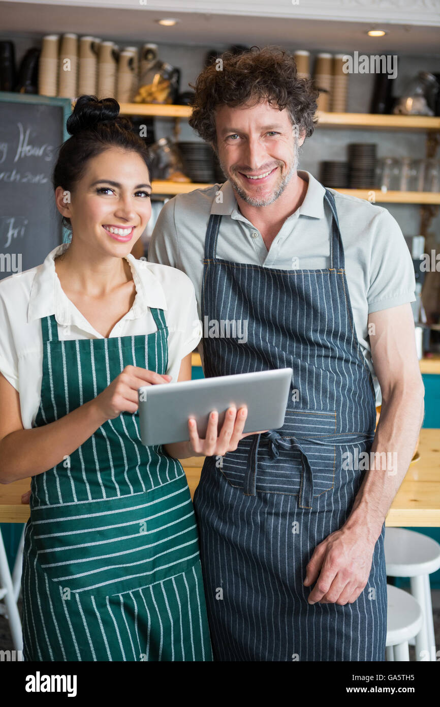 Portrait of waiter and waitress holding digital tablet Stock Photo - Alamy