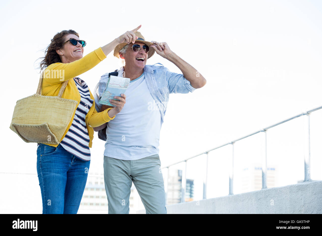 Happy couple with map in city Stock Photo - Alamy