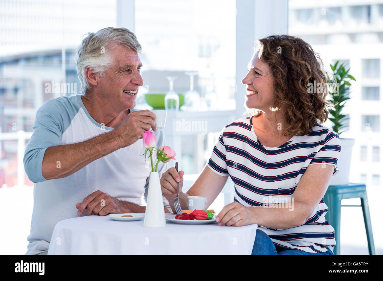 Happy couple interacting at restaurant Stock Photo - Alamy