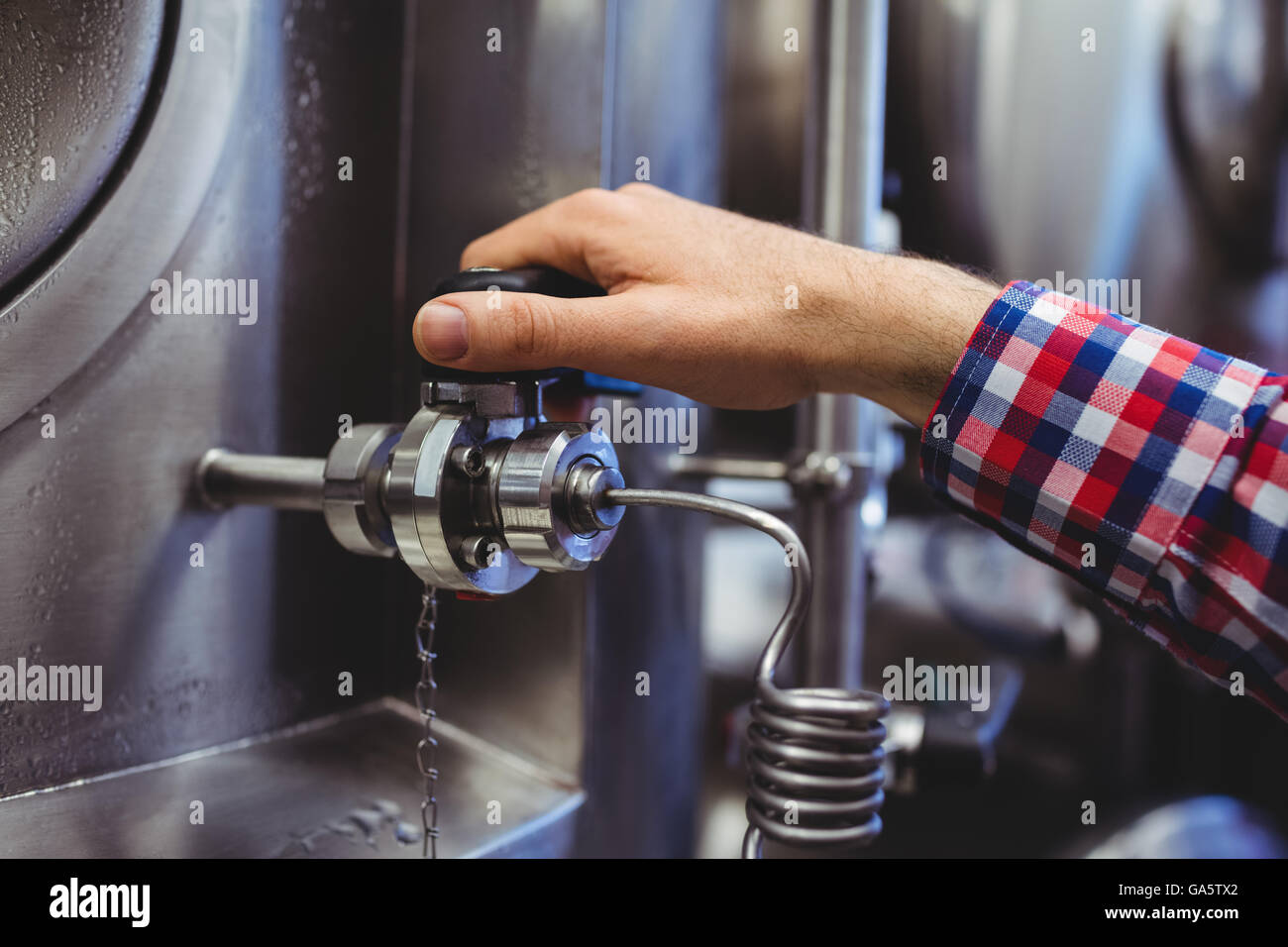 Man opening valve of machinery Stock Photo - Alamy
