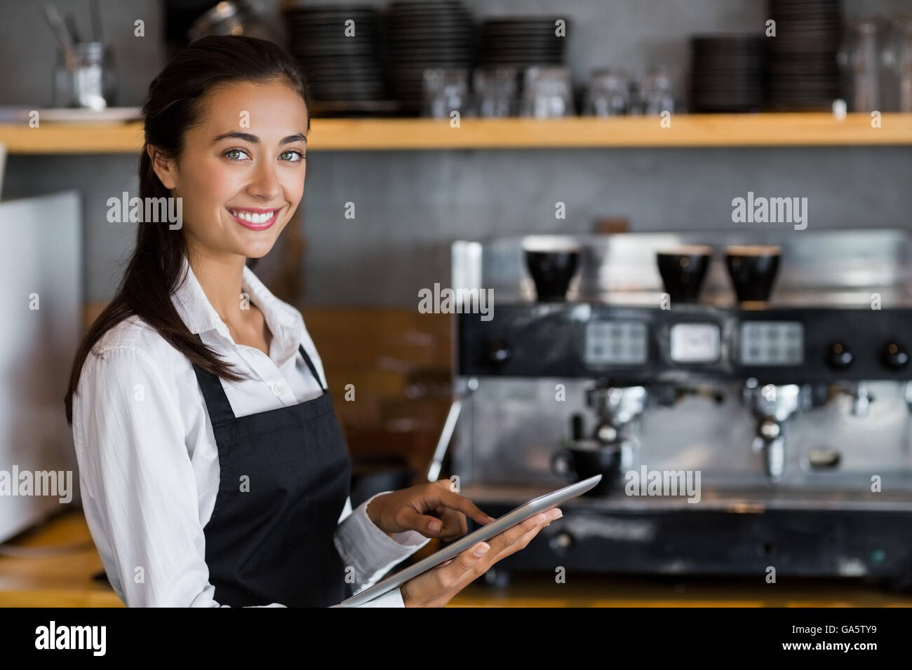 Portrait of smiling waitress using digital tablet Stock Photo - Alamy
