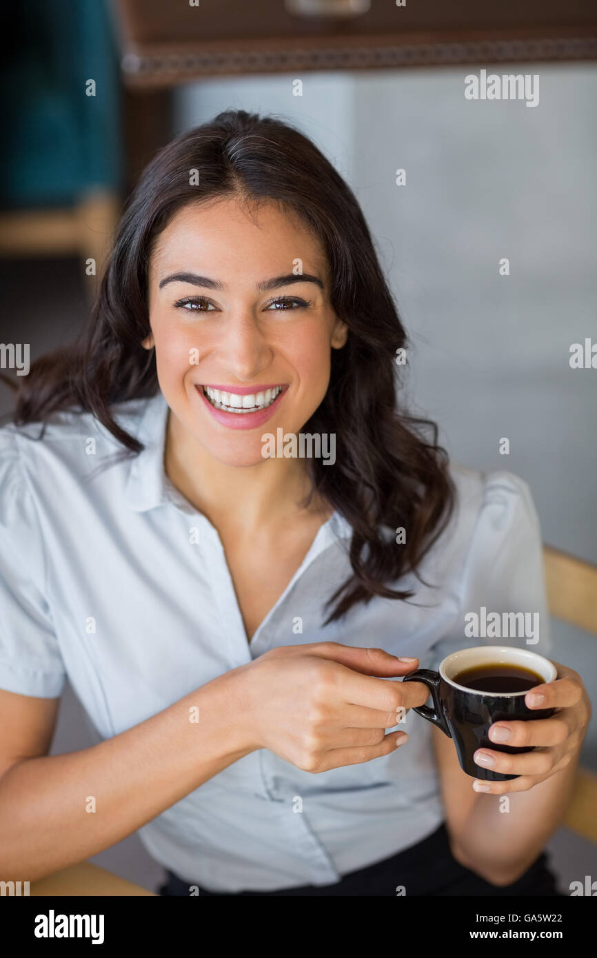 Portrait of smiling woman having cup of coffee Stock Photo - Alamy