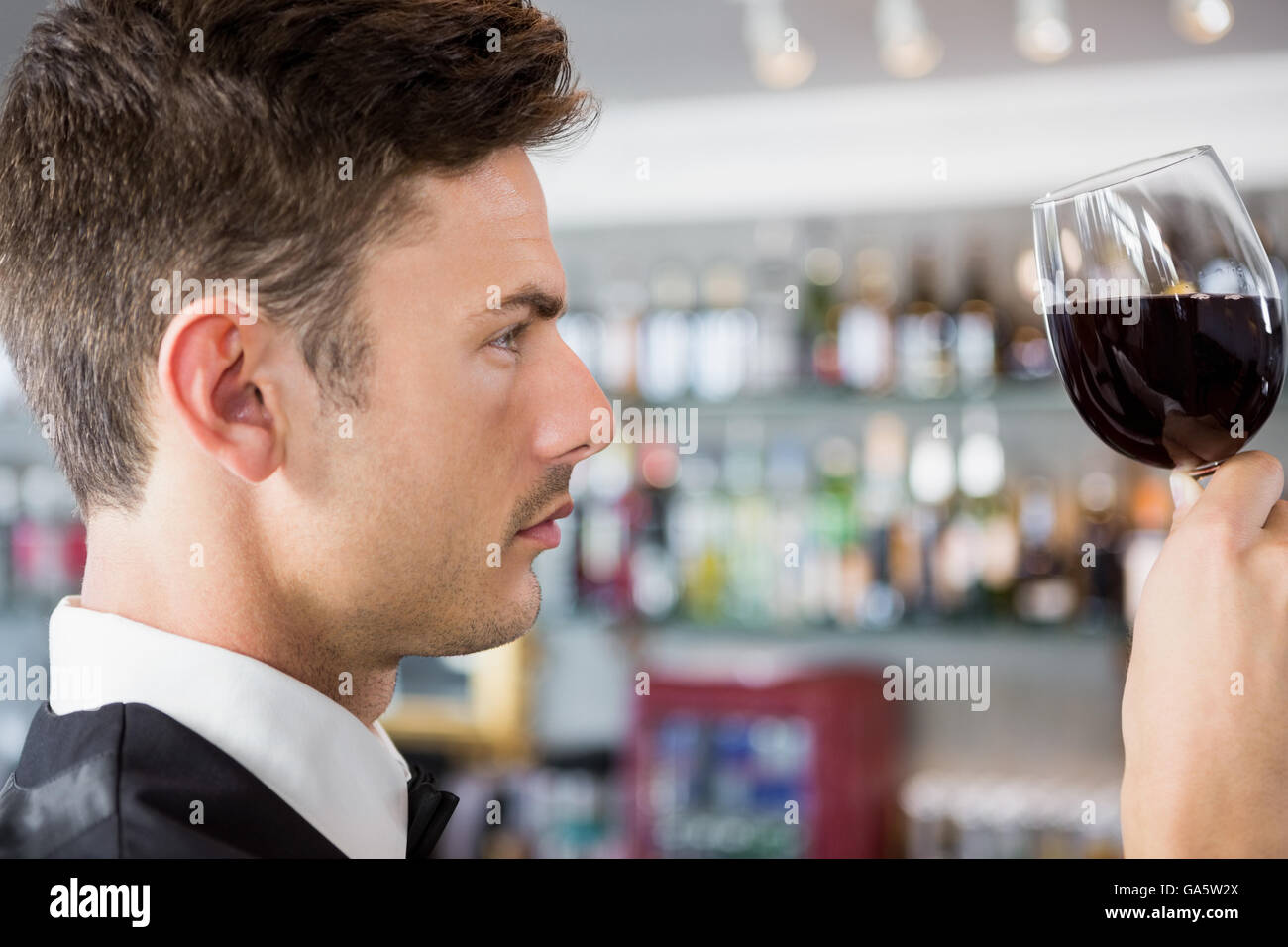 Waiter looking at a glass of wine Stock Photo - Alamy