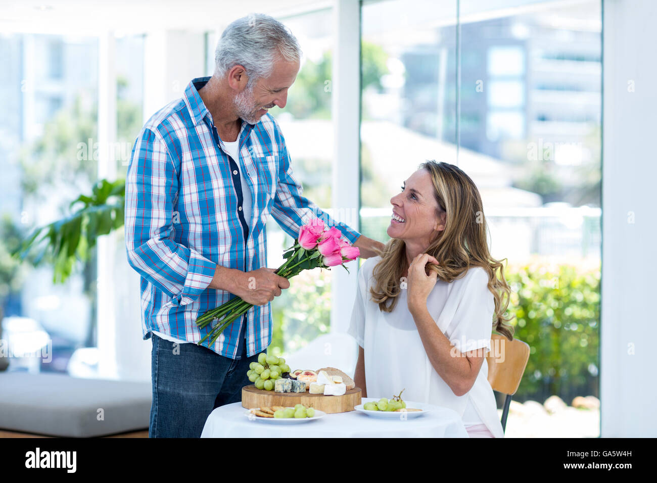 Man giving roses to woman in restaurant Stock Photo - Alamy