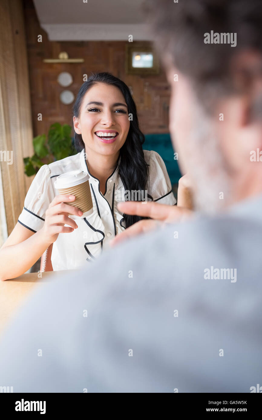 Sitting holding smiling hand on chin food and drink communication hi ...