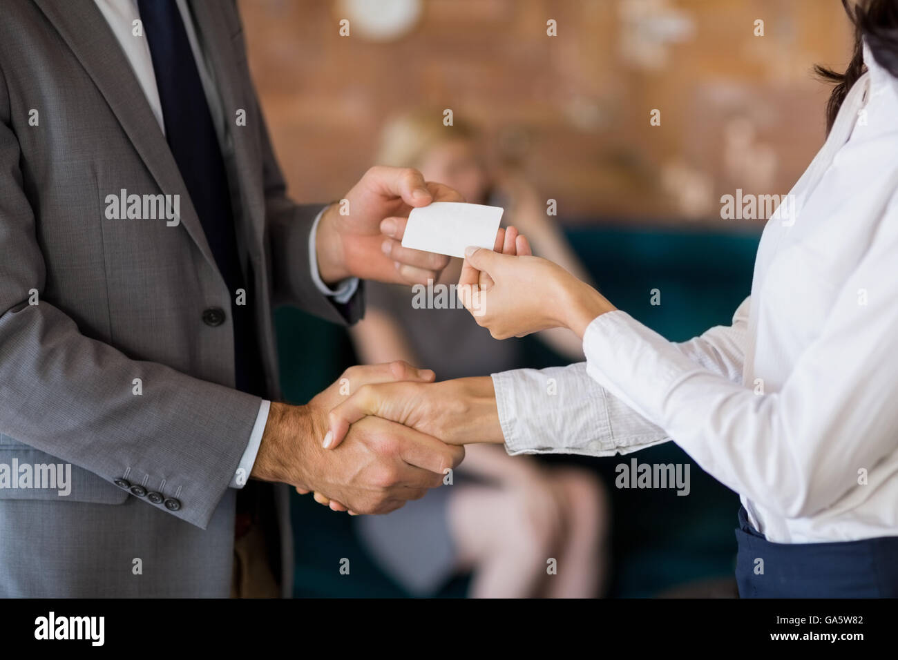 Business colleagues exchanging business card Stock Photo - Alamy