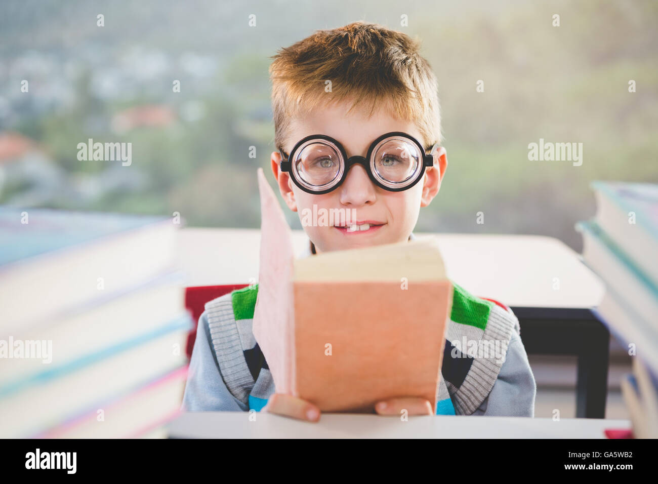 Portrait of schoolkid reading book in classroom Stock Photo - Alamy