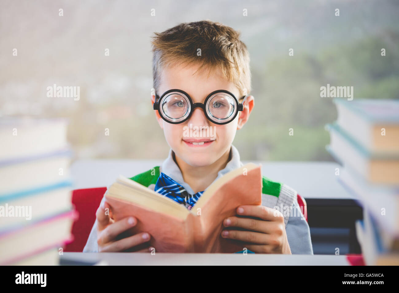 Portrait of schoolkid reading book in classroom Stock Photo - Alamy