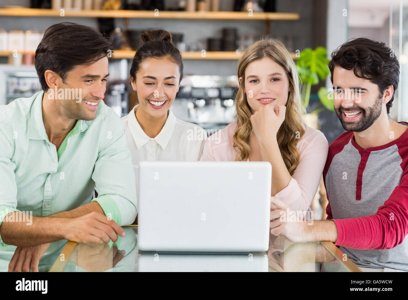 Group of happy friends using laptop Stock Photo - Alamy