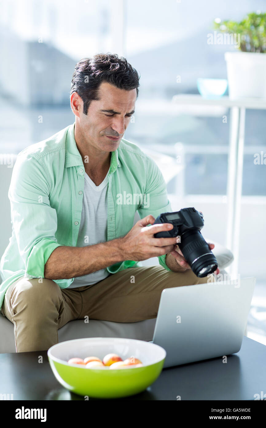 Young man holding camera at home Stock Photo - Alamy