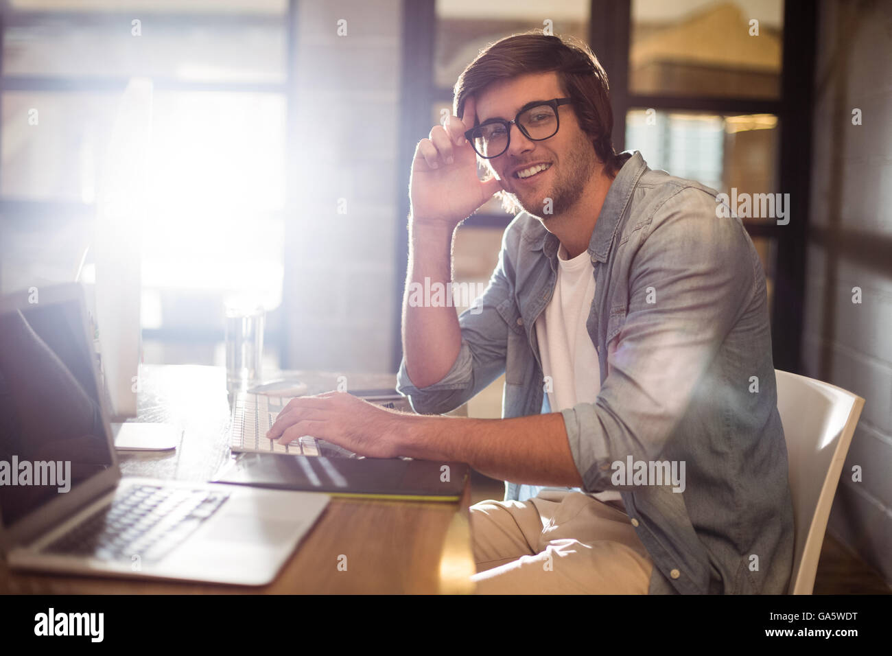 Portrait of smiling man working in office Stock Photo - Alamy