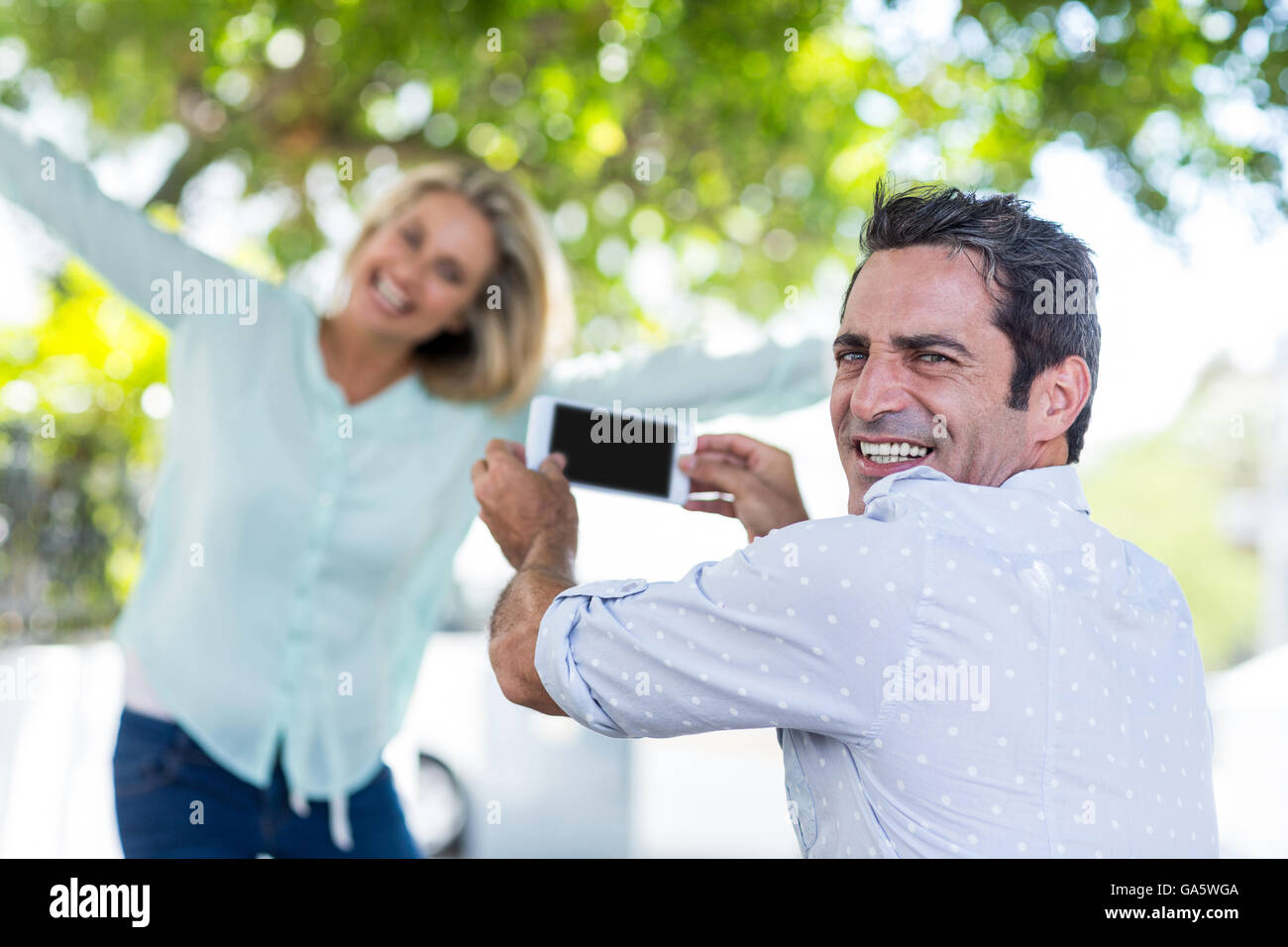 Happy man photographing woman Stock Photo - Alamy