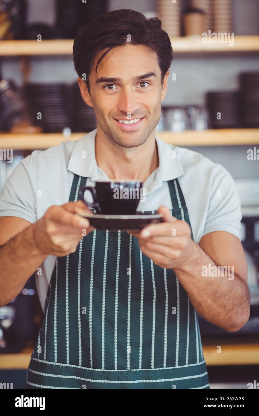 Waiter offering a cup of coffee Stock Photo - Alamy