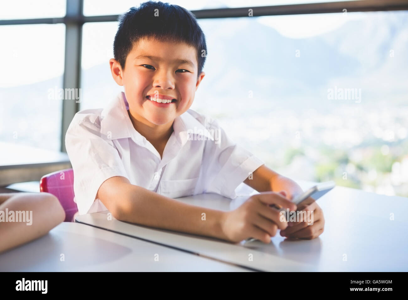 Schoolkid using mobile phone in classroom Stock Photo - Alamy