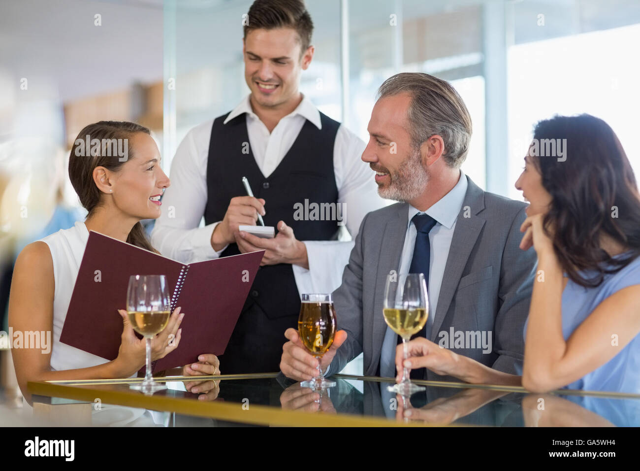 Waiter taking the order from a businessman and his colleagues Stock ...