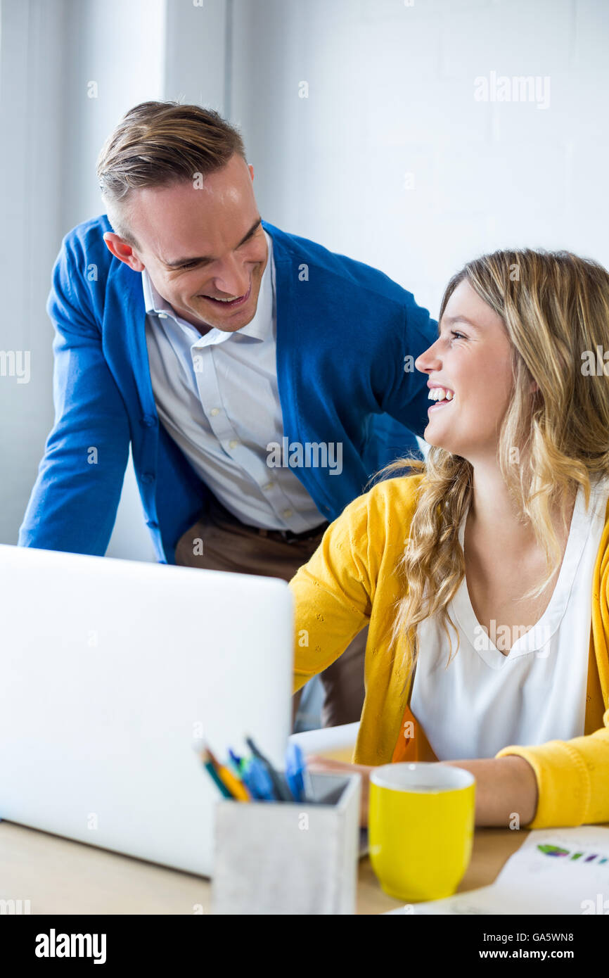 Happy colleagues talking in office Stock Photo - Alamy