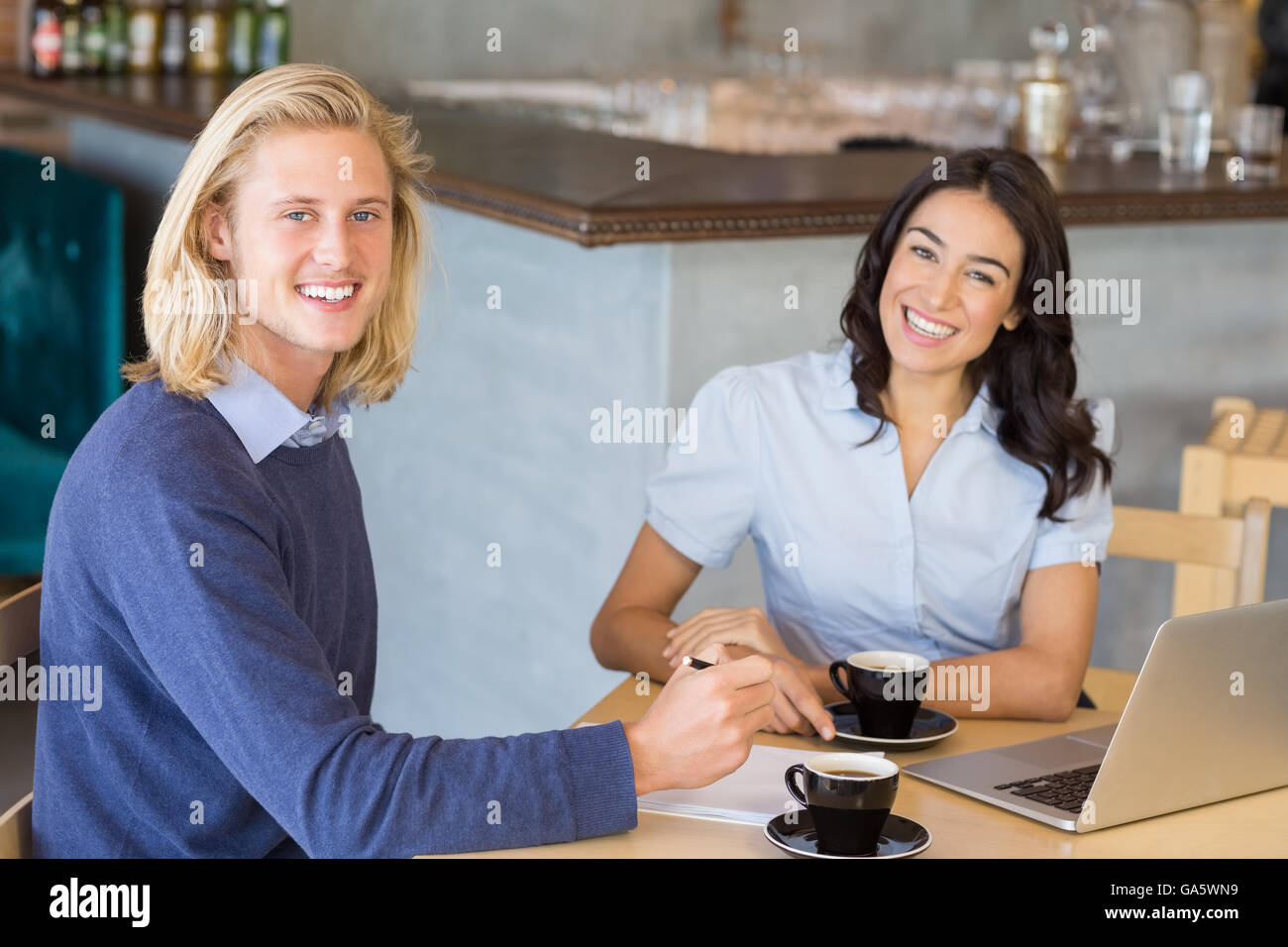 Business colleagues smiling while having a cup of tea Stock Photo - Alamy