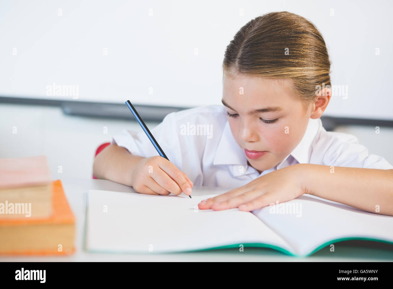 Schoolkid doing homework in classroom Stock Photo - Alamy