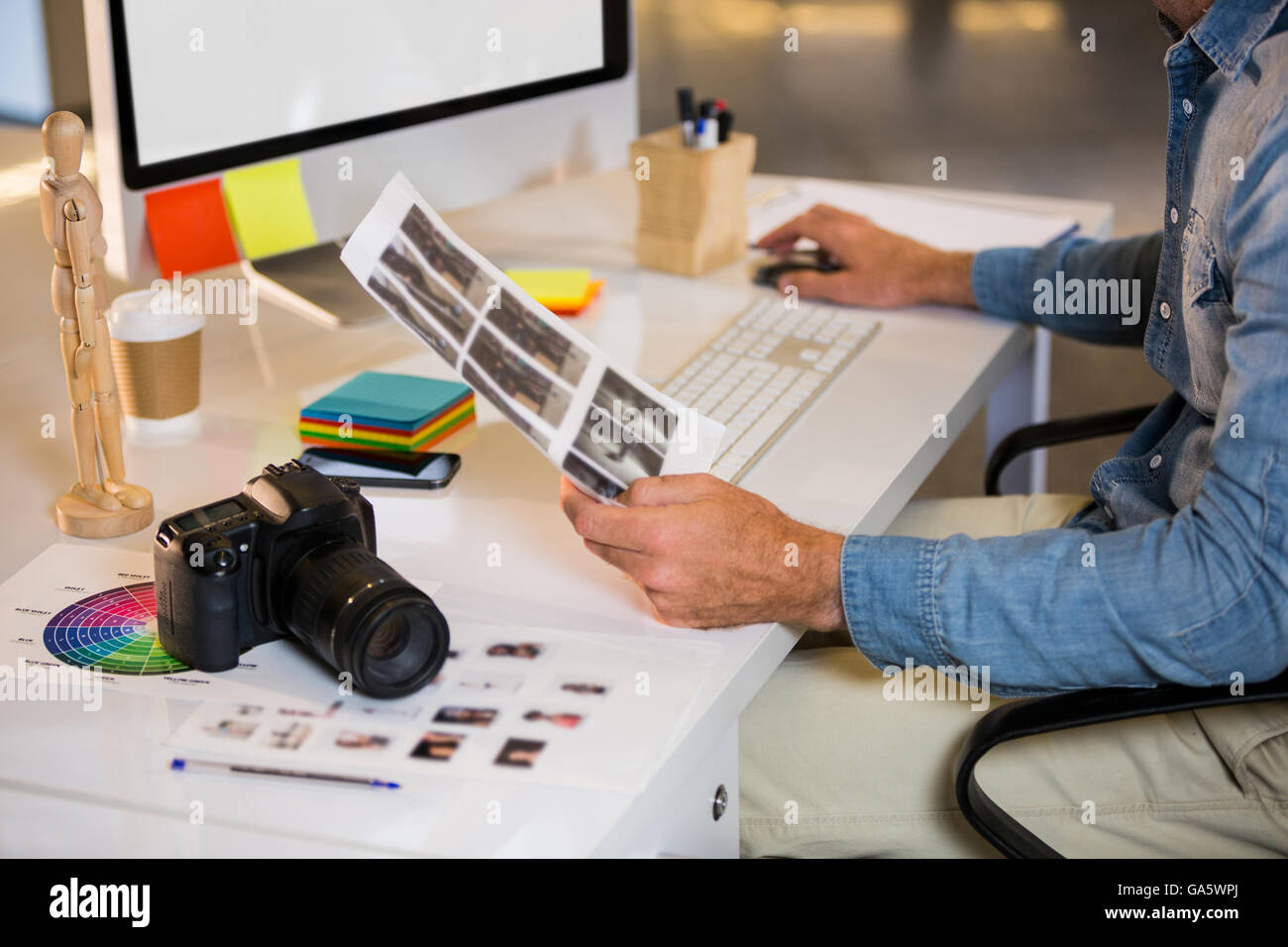 Photo editor working at computer desk Stock Photo - Alamy