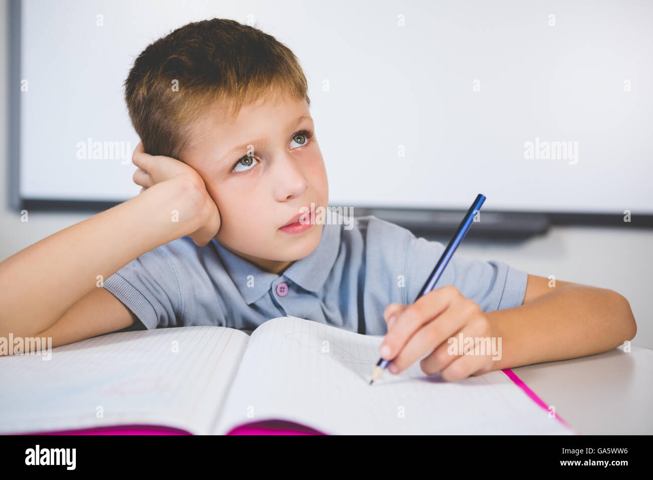 Schoolboy doing homework in classroom Stock Photo - Alamy