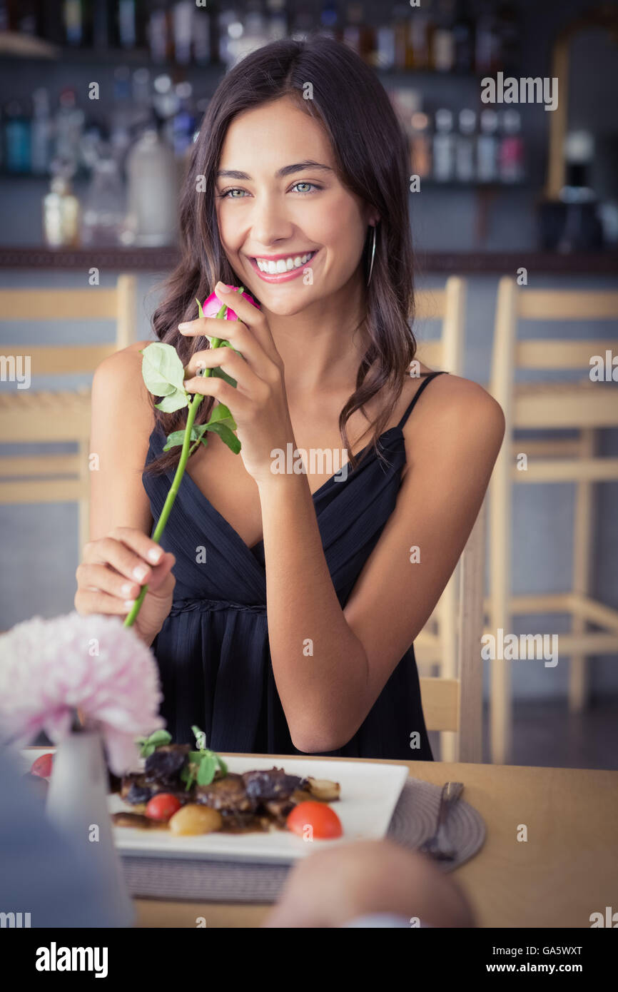 Beautiful woman holding rose flower and smiling Stock Photo - Alamy