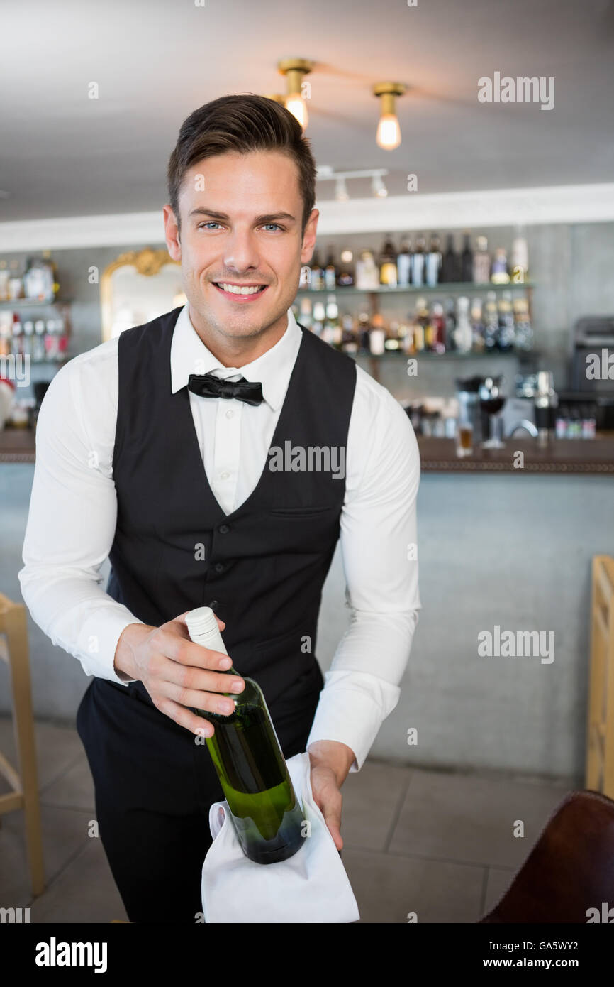Waiter holding a bottle of wine Stock Photo - Alamy